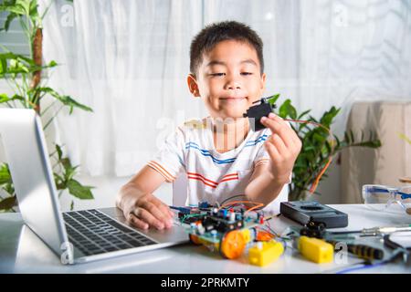 Little student child holding stepping motor to assemble car toy, Asian ...