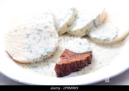beef meat with dill sauce and dumplings Stock Photo - Alamy
