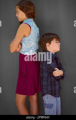 Sibling rivalry. Studio shot of a young brother and sister standing ...