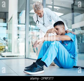 Crying stressed and tired medical nurse sitting on floor of hospital ...
