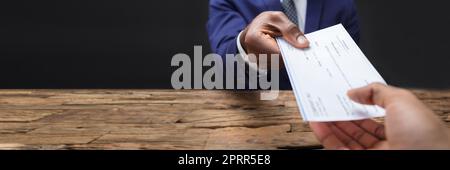 Giving Payroll Cheque. Hand Holding Compensation Check Stock Photo - Alamy