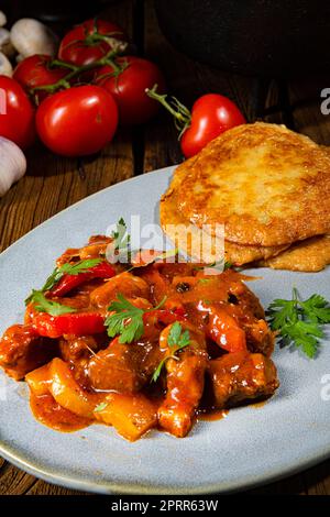 potato pancakes with spicy stew, delicious traditional dish, Hungarian ...