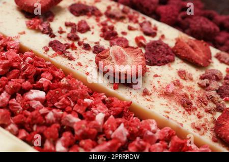 Chocolate bar with freeze dried strawberries and cherries as background ...