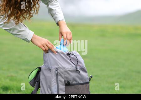 Close up of a hiker hands putting canteen in a backpack Stock Photo - Alamy