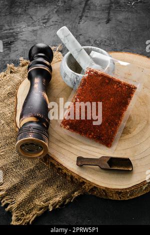 Wooden cross section with paprika in plastic package and mortar and ...