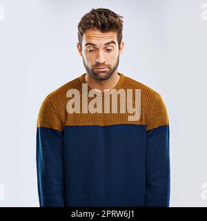 Sigh,I wish it was different...Studio shot of a young man looking ...