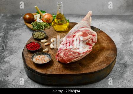 Raw whole lamb leg chump on with ingredients on wooden stump Stock ...