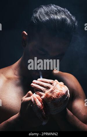 Fighter, boxer blood and man smoking a cigarette after a exercise fight ...