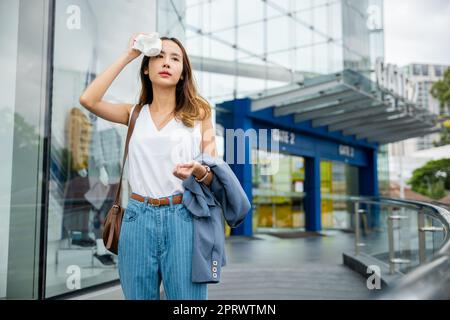 Asian beautiful business woman drying sweat her face with cloth in warm ...