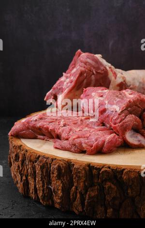 Raw lamb neck meat on a marble board..Black background. Top view. Copy ...