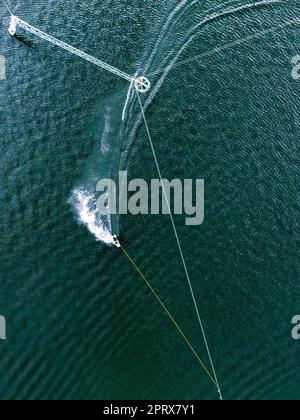 Aerial wakeboarding. Top view of awakeboard rider in wake cable park ...