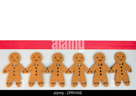 Gingerbread men in a line, red ribbon Stock Photo - Alamy