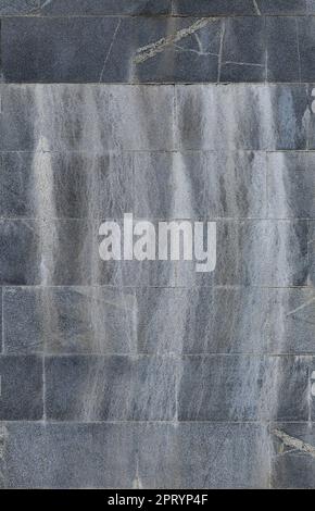 The texture of a wall of large granite tiles that are covered with ...