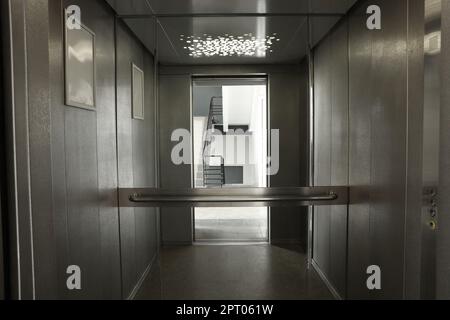 Open elevator`s cabin with big mirror indoors Stock Photo - Alamy