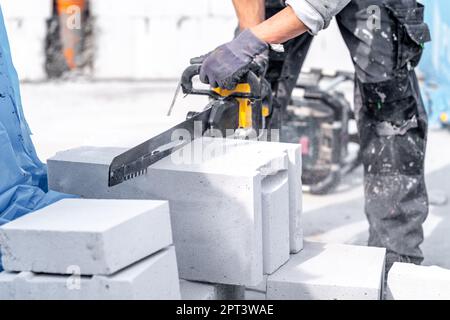 cutting concrete blocks with a saw during the construction of a ...