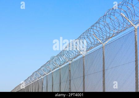demarcation fence with barbed wire against blue sky Stock Photo - Alamy