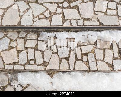 Melting snow on cobblestone pavement steps Stock Photo - Alamy