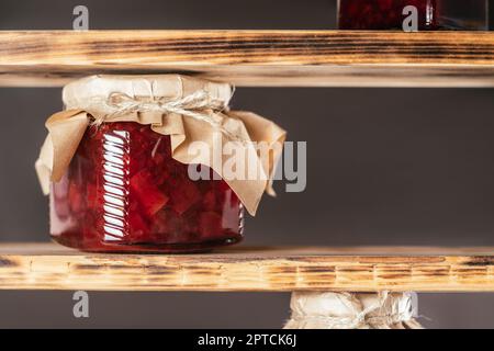 Jar of homemade lingonberry and pear jam with craft paper on lid on ...