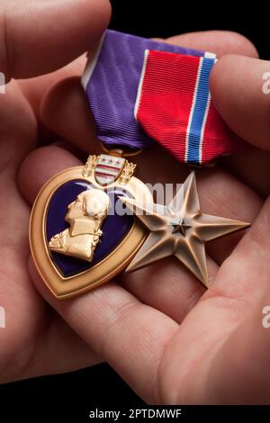 Man Holding Purple Heart and Bronze War Medals in The Palm of His Hand ...