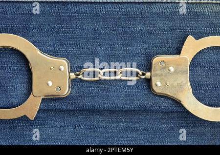 Police steel handcuffs lying on dark blue jeans background Stock Photo ...