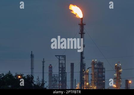 Torch nozzle at an oil refinery flame in the dark burning of excess gas ...