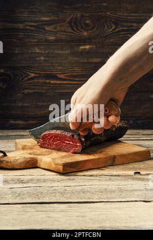 hand cutting slice of garlic bread with knife Stock Photo - Alamy