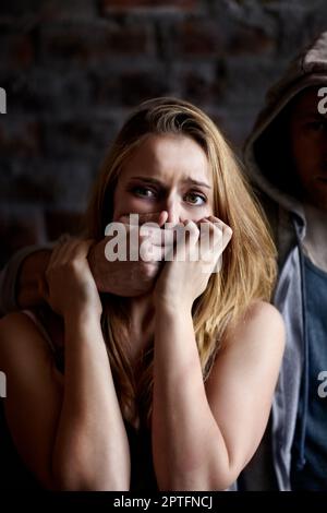Forced into silence. Abused young woman being silenced by her abuser ...