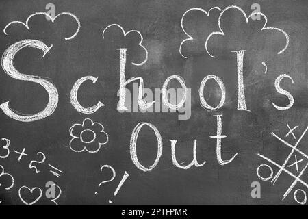 Blackboard with text SCHOOL'S OUT, drawings and desk in classroom Stock ...