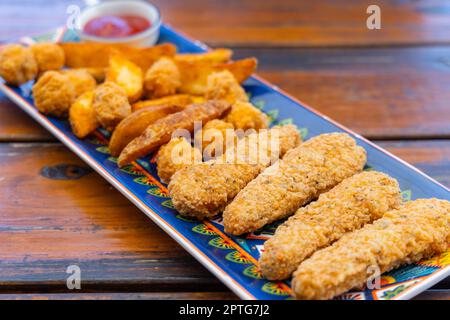 Fry fish fingers w lemon tomato and potato chips Stock Photo - Alamy
