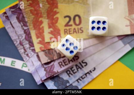 Small dice cubes with brazilian money bills on flag of Brasil Republic ...