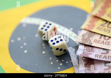 Small dice cubes with brazilian money bills on flag of Brasil Republic ...