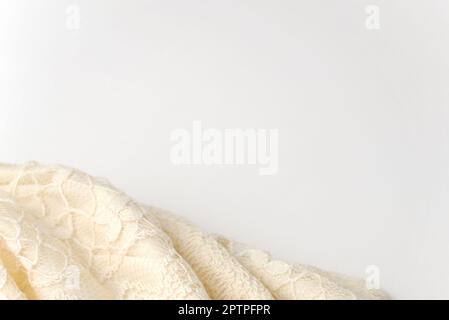 Ivory color crochet sweater on white background. Texture detail close ...