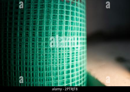 Green reinforcing mesh close-up. Facade fiberglass mesh on a blurred ...