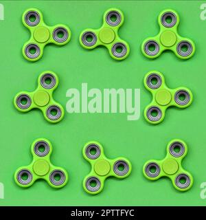 Green fidget spinner lies on texture background of fashion pastel green ...