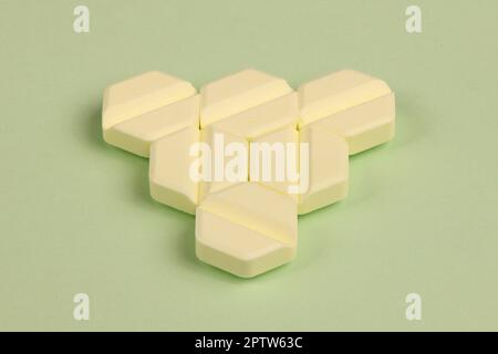 Hexagonal pills on light green background. Extreme closeup. High ...