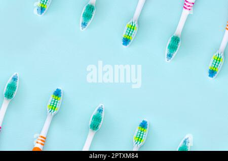 A lot of toothbrushes lie on a pastel pink background. Top view, flat ...