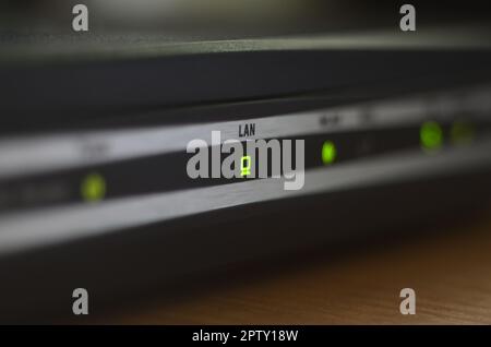 Macro of internet modem, abstract technology background. Green "LAN ...