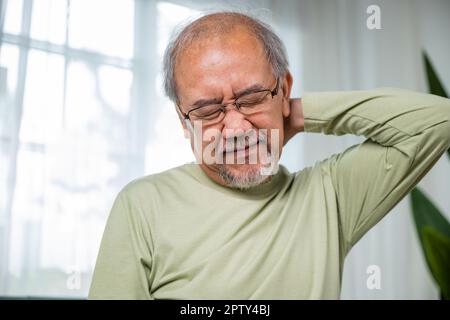 Old man suffering from nape neck pain at home Stock Photo - Alamy