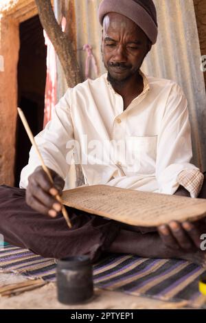 An IDP man practices Islamic calligraphy in Segou Region, Mali, West ...