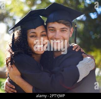 Best friends and grads. Portrait of two students embracing each other ...