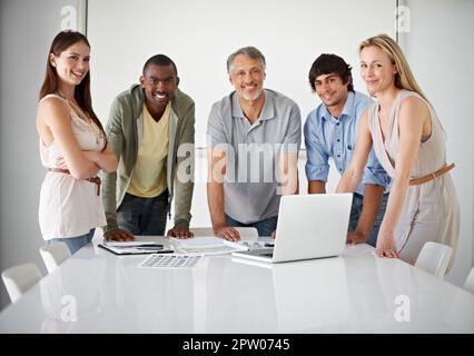 Using the laptop to their advantage. Five colleagues using a laptop in ...