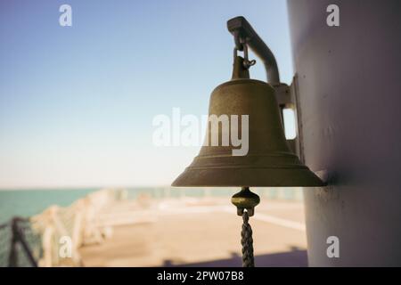 Antique brass ship's bell on a metal wall Stock Photo - Alamy