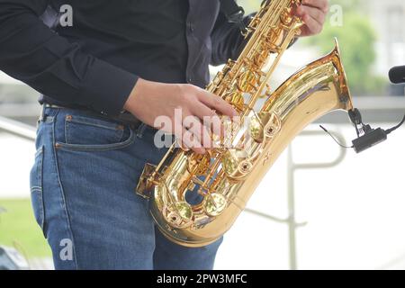 male's hands playing the saxophone outdoors Stock Photo - Alamy