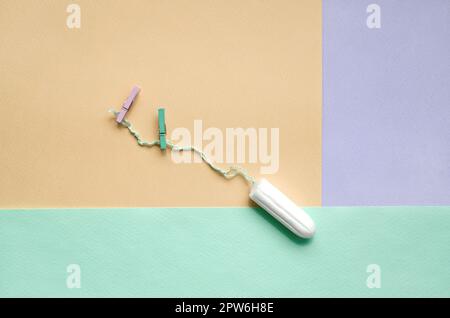 Tampon with two clothespins lie on texture background of fashion pastel ...