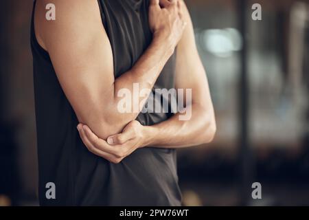 Hands of a bodybuilder with arm pain. Fit man with a sore bicep cropped ...