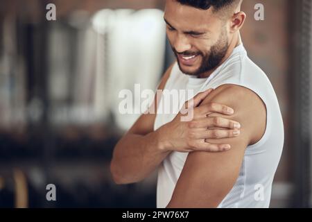Fit man experiencing arm cramp. Bodybuilder with shoulder pain in the gym. Athlete with physical ...