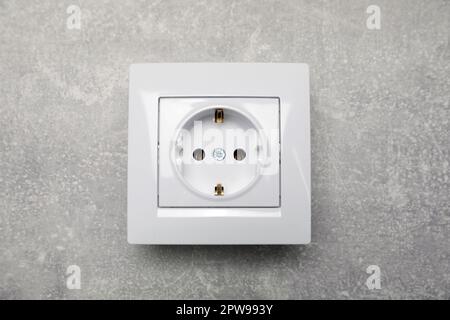 Modern plastic power socket on grey table, top view. Space for text ...
