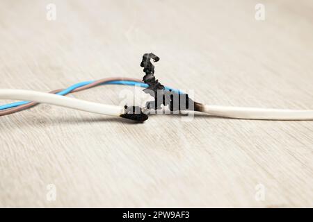 Burnt wires on wooden floor, closeup. Electrical short circuit Stock ...
