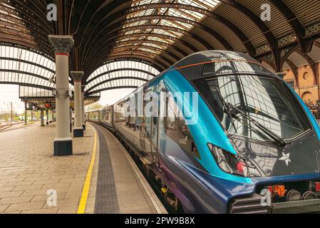A train waits in a siding under a historic 19th Century metal canopy ...