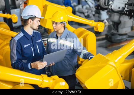 engineer team working together inspection quality robot arm in robot assembly industry plant ...